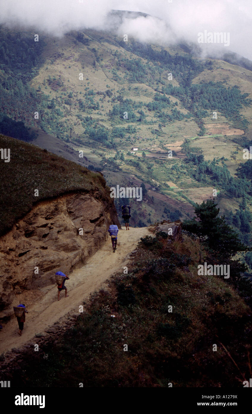 Porters make their way up steep paths in the foothills of the Himalayas ...