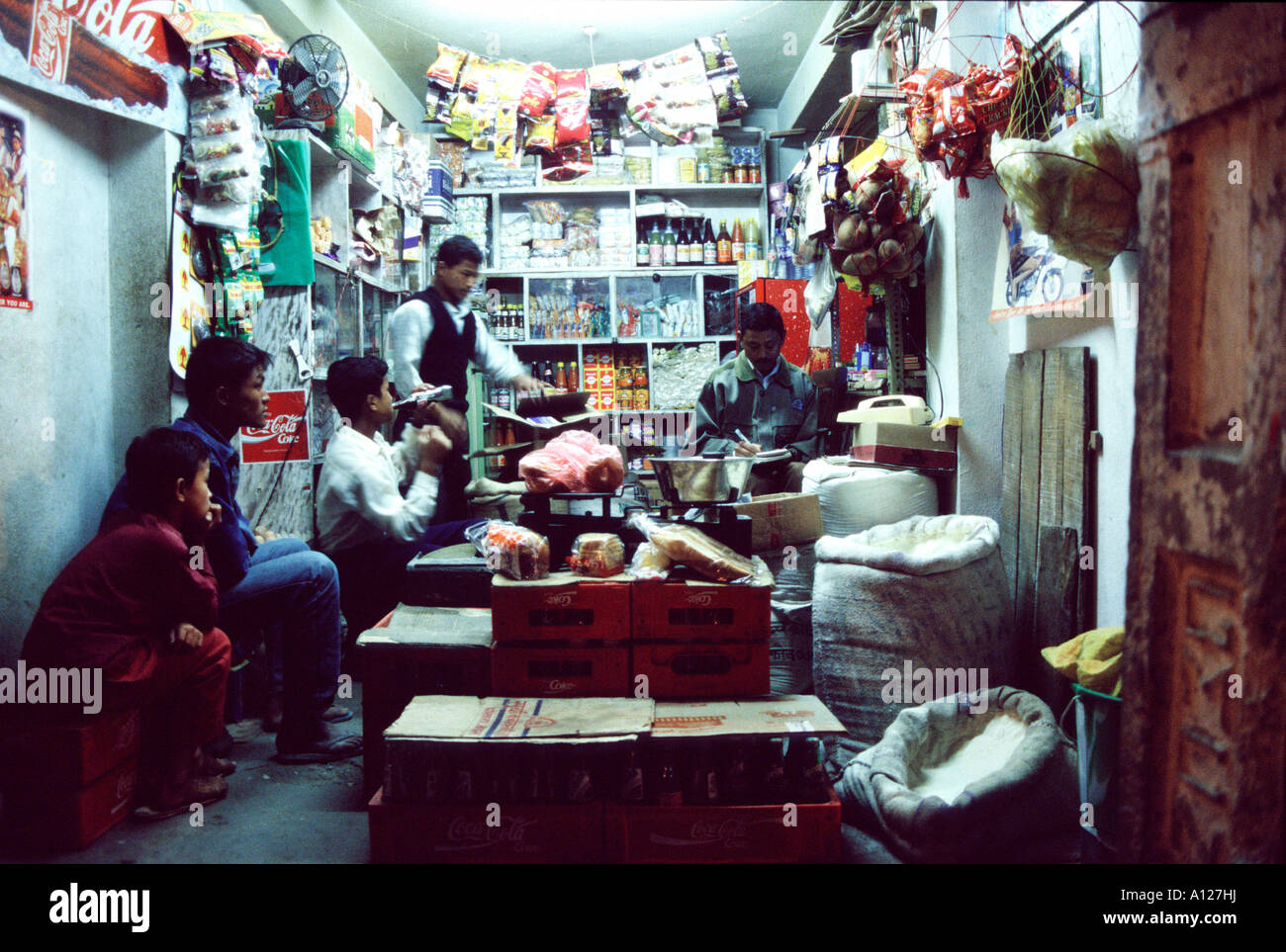 A family gathers inside a roadside shop in Thamel, Kathmandu, Nepal ...
