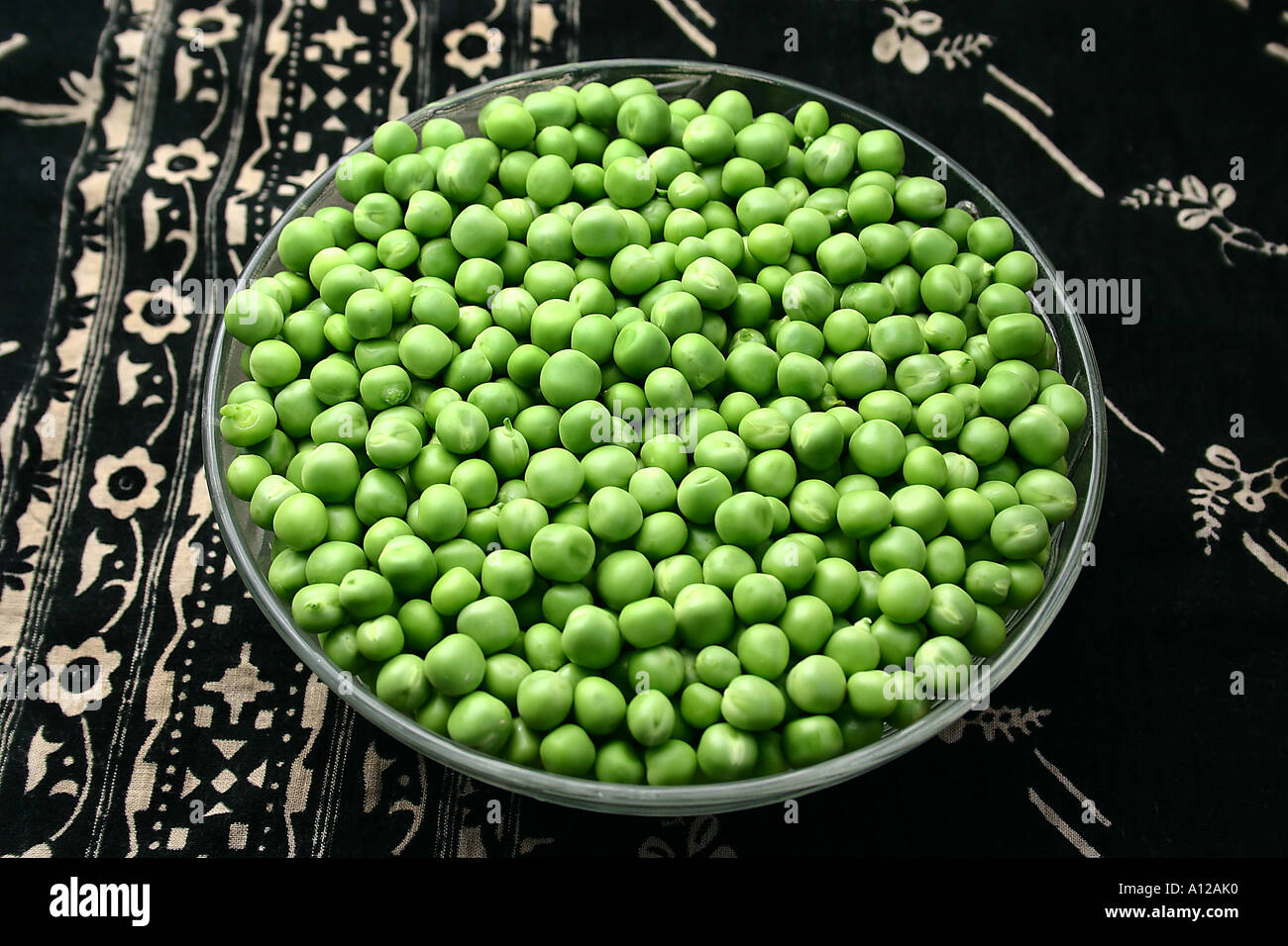 Vegetable fresh green peas peeled in a round dish ready to cook healthy ...