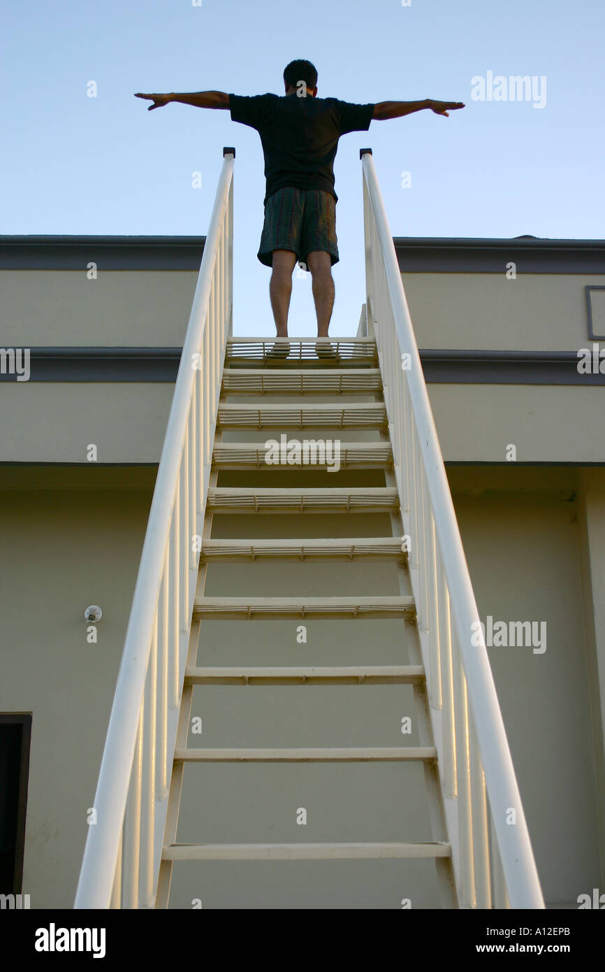 Man exercise on top of steps roof of house bungalow leading iron ...