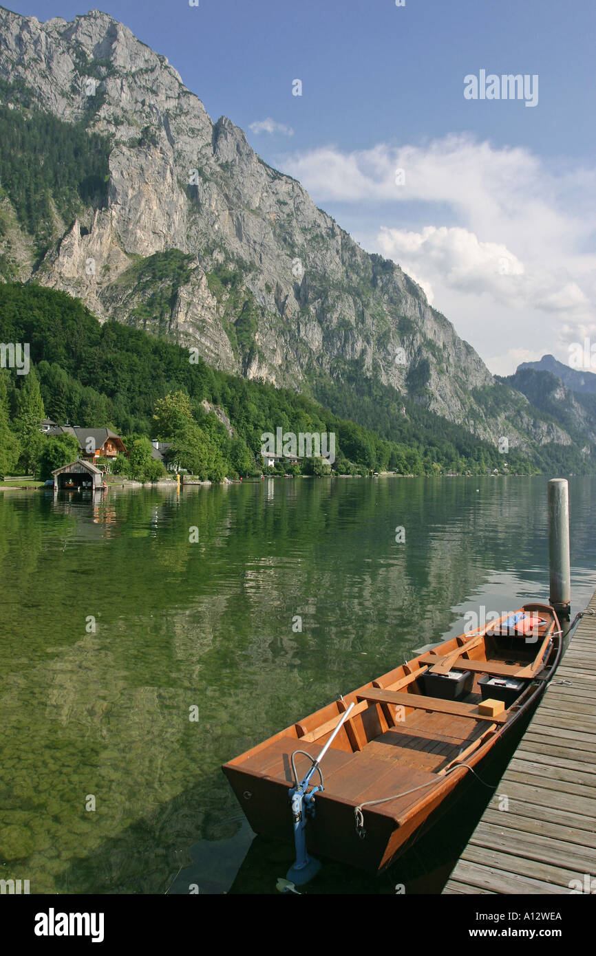 a traditional rowing boat at the Traun lake at the background the ...