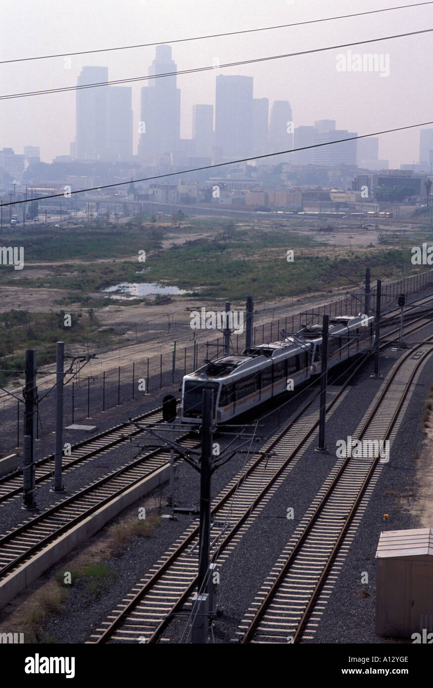 The Metro train and train tracks in front of the Los Angeles skyline ...