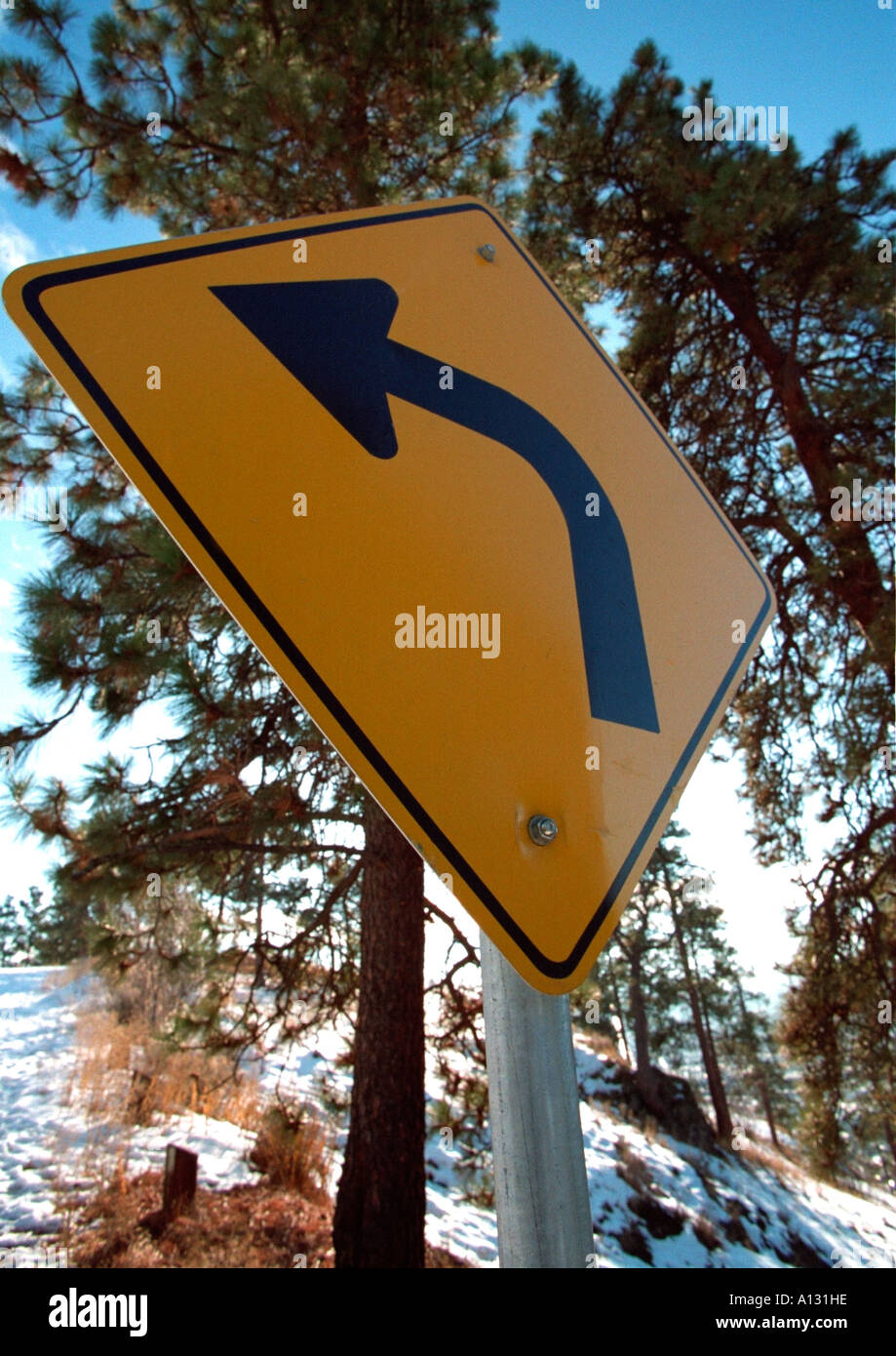 Yellow left hand bend sign Stock Photo - Alamy