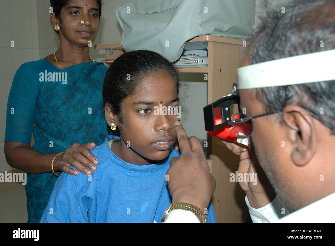 A teenage girl having a check up after successful cataract surgery in ...