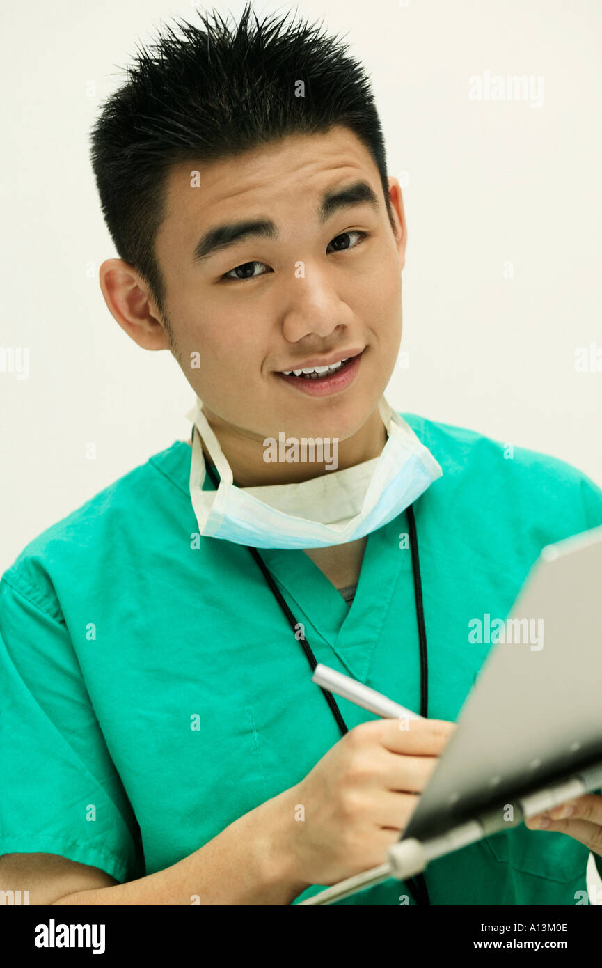 Male doctor writing in medical chart Stock Photo - Alamy
