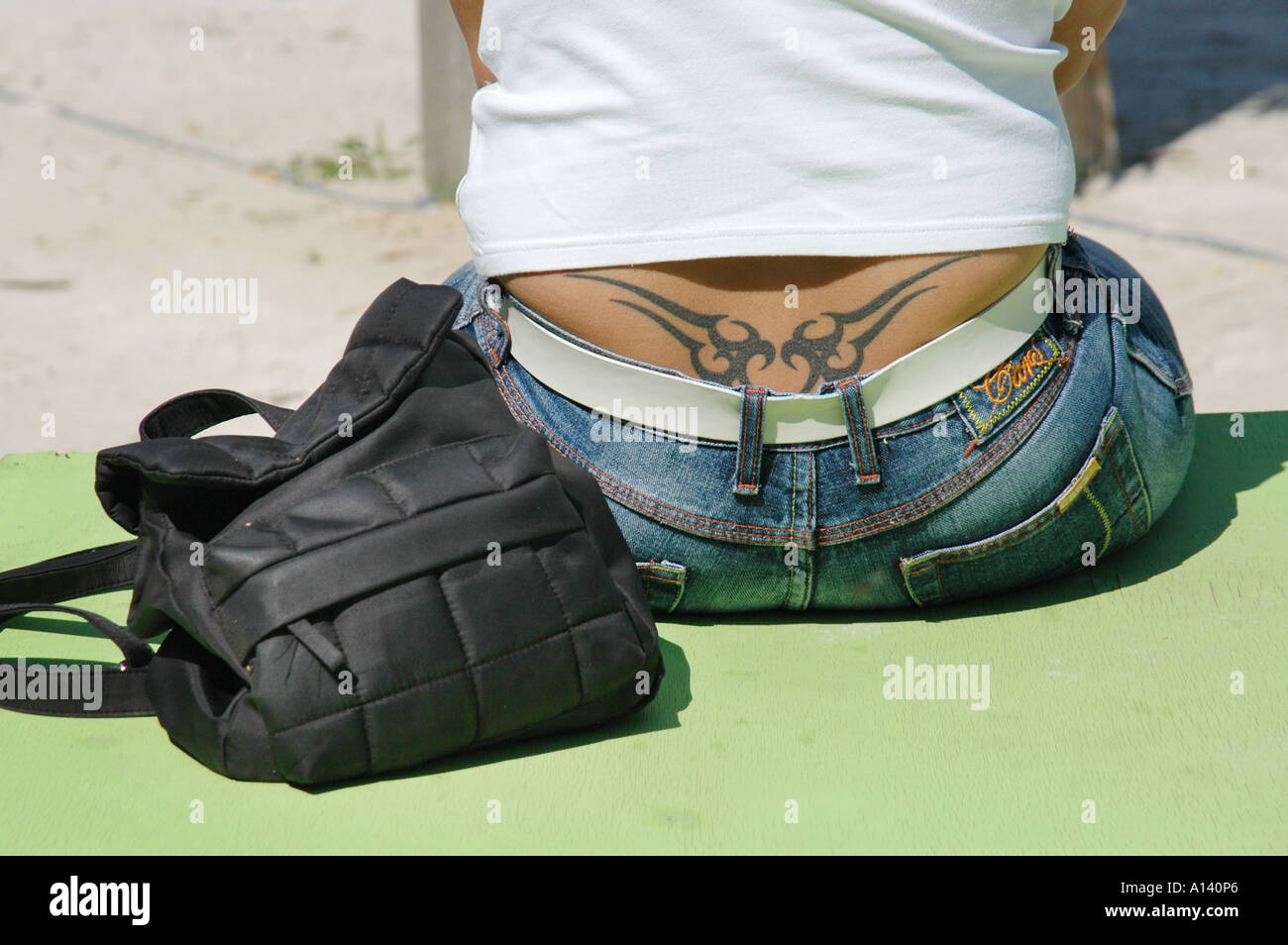 young lady showing off her tattoo on lower back Stock Photo - Alamy
