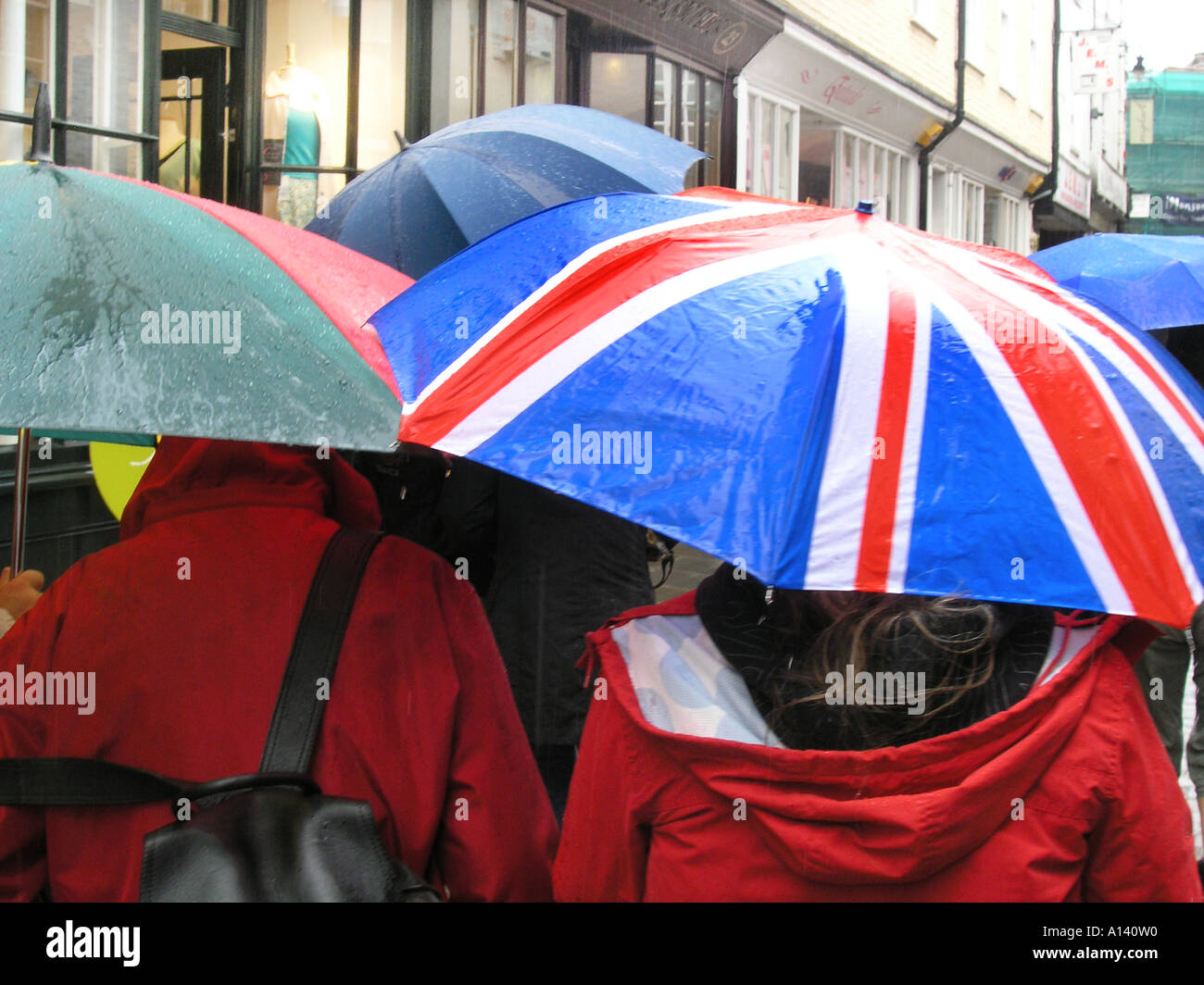 seeking shelter from the rain under Union Jack umbrella Stock Photo - Alamy