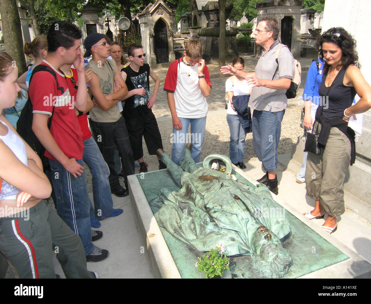 a party of students visiting grave of Victor Noir at Pere Lachaise ...
