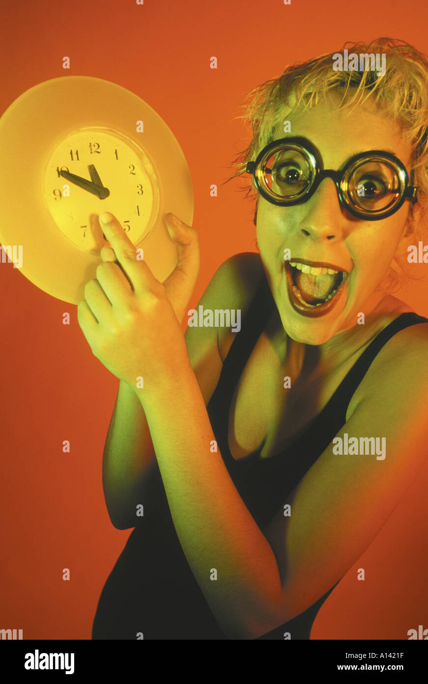 WOMAN HOLDING UP A CLOCK Stock Photo - Alamy
