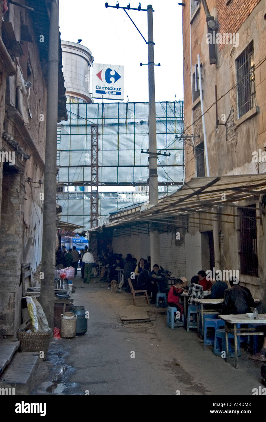 A small alley with street food and a large Carrefour shopping mall ...