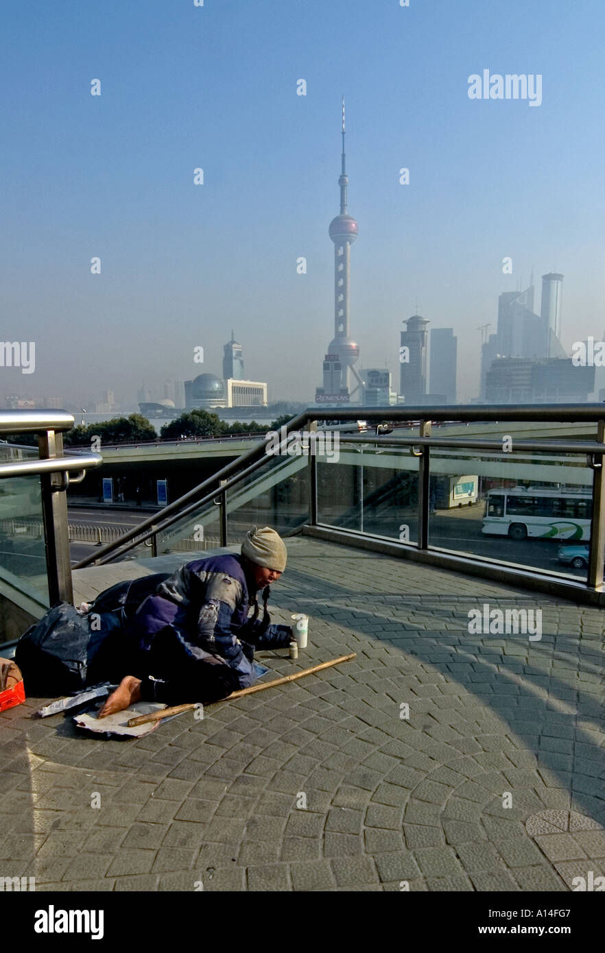 A Chinese homeless begging in Shanghai's street. In background can be ...