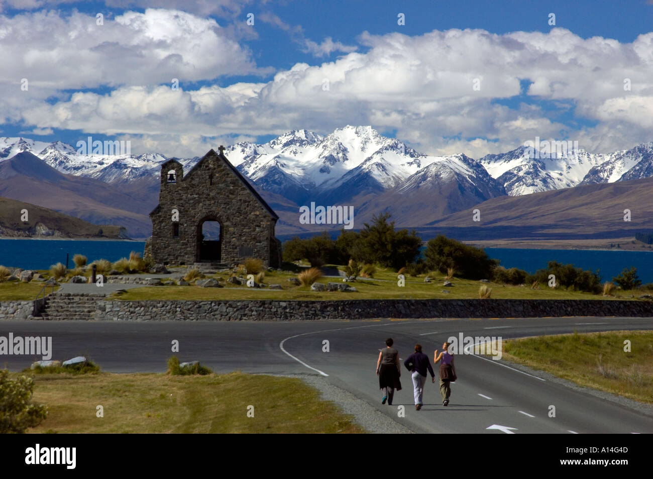 Three walkers approach the Church of the Good Shepherd on Lake Tekapo ...