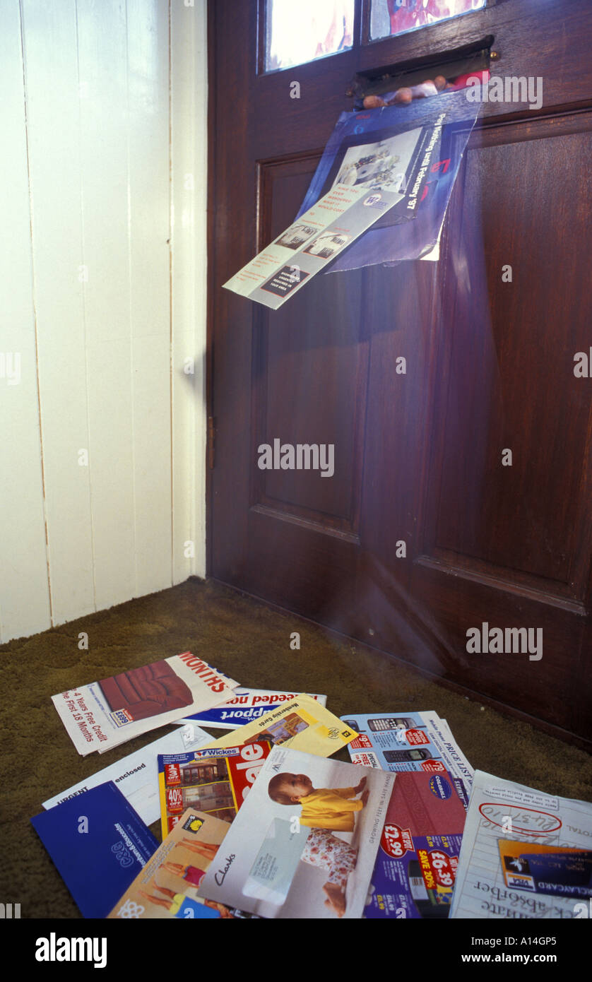 Junk mail being pushed through a letterbox of a house in England UK ...