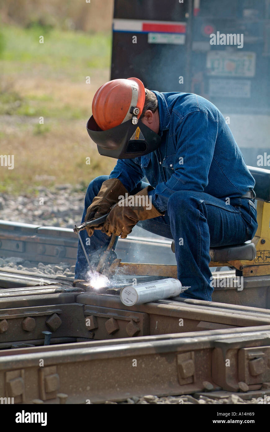 Welder performs repairs and maintenance on a section of a railroad ...