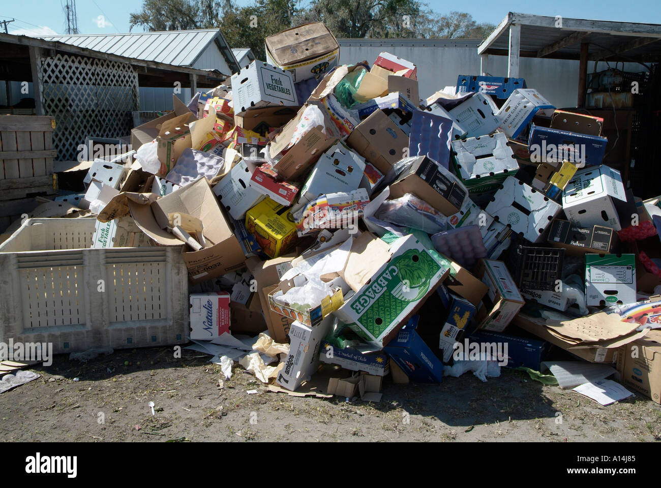 Cardboard boxes are staked outside of a business ready for recycling ...