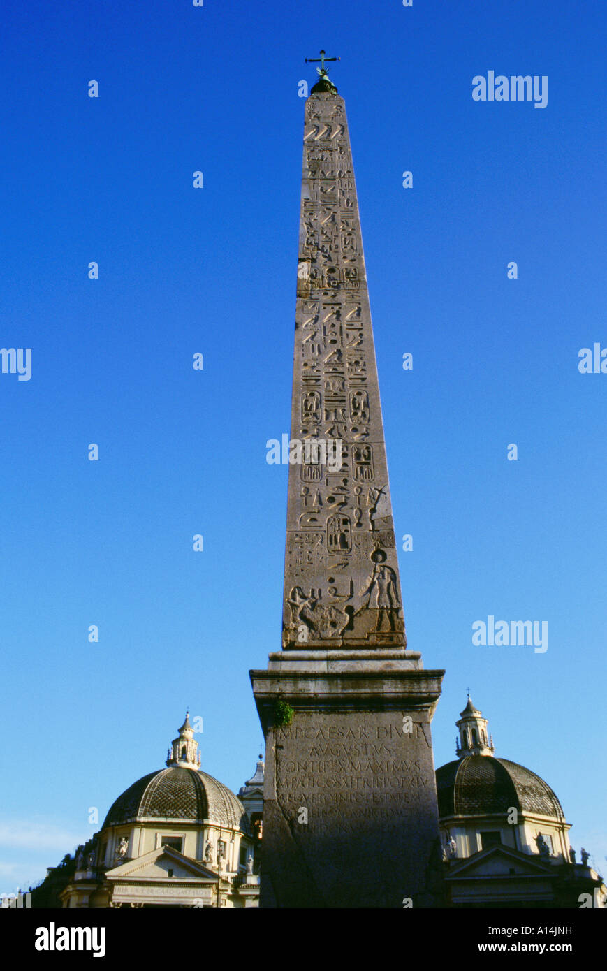 Egyptian obelisk with twin churches against blue sky at the Piazza del ...