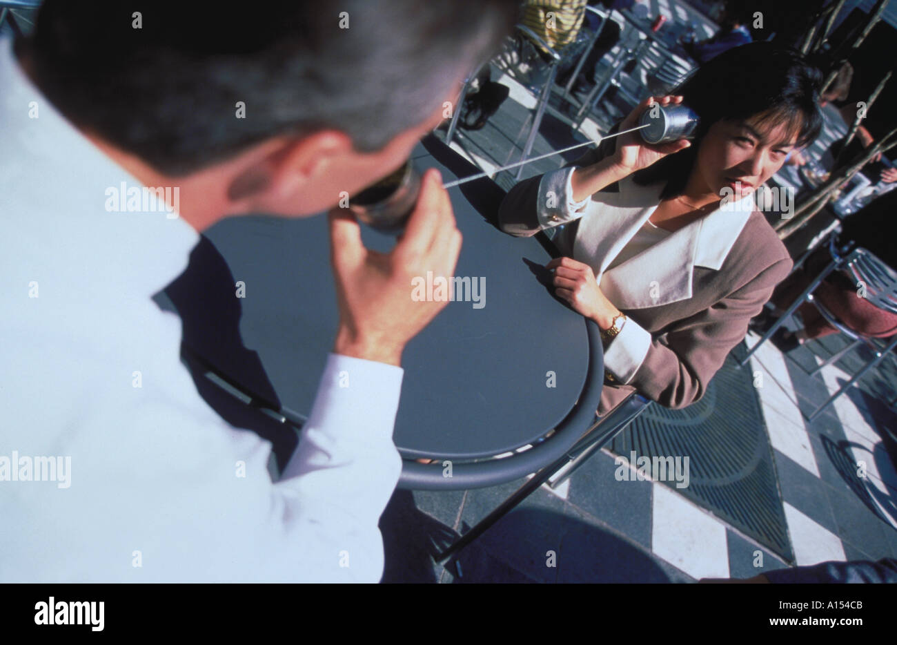 Two business people sitting outside talking across a string between two ...