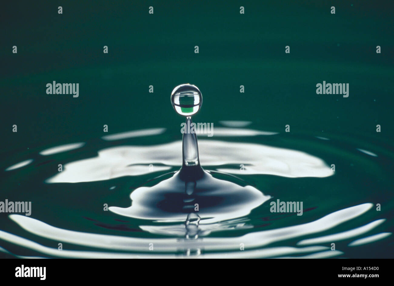 A water drop falls into green water Stock Photo - Alamy