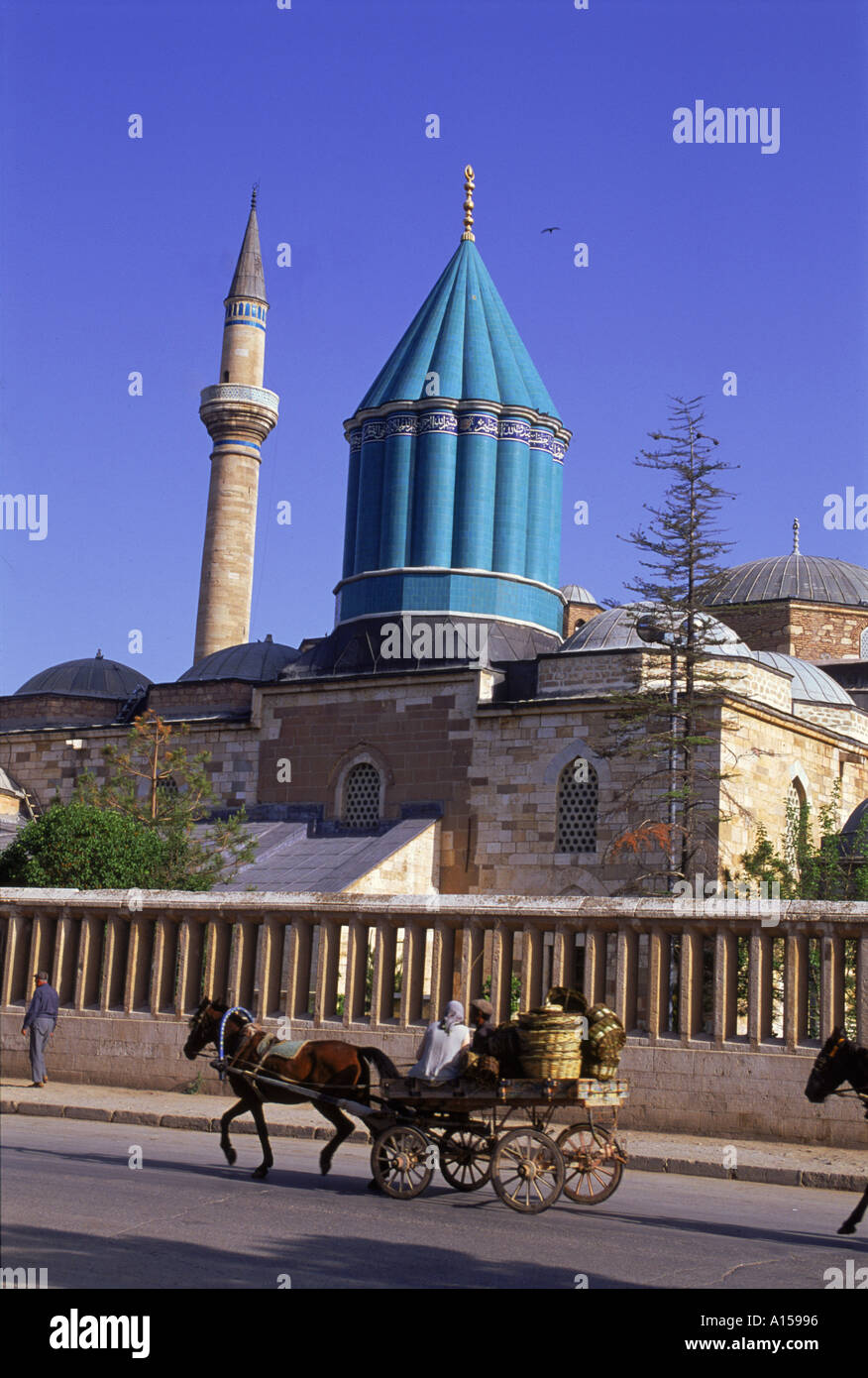 Horse and cart passes the Mevlana Tekke Museum with its green tower and ...