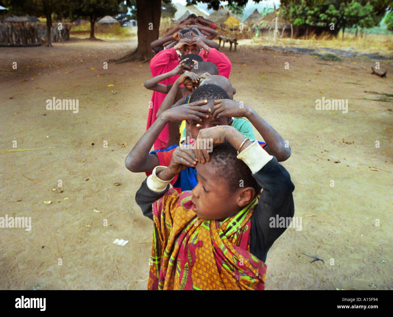 The religious leader in a Fulani village disciplines children before ...