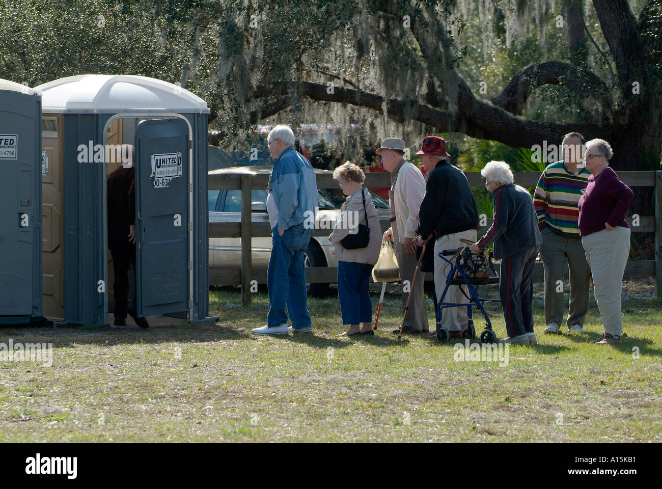 Male and female patron at a festival line up to use the porta johns ...