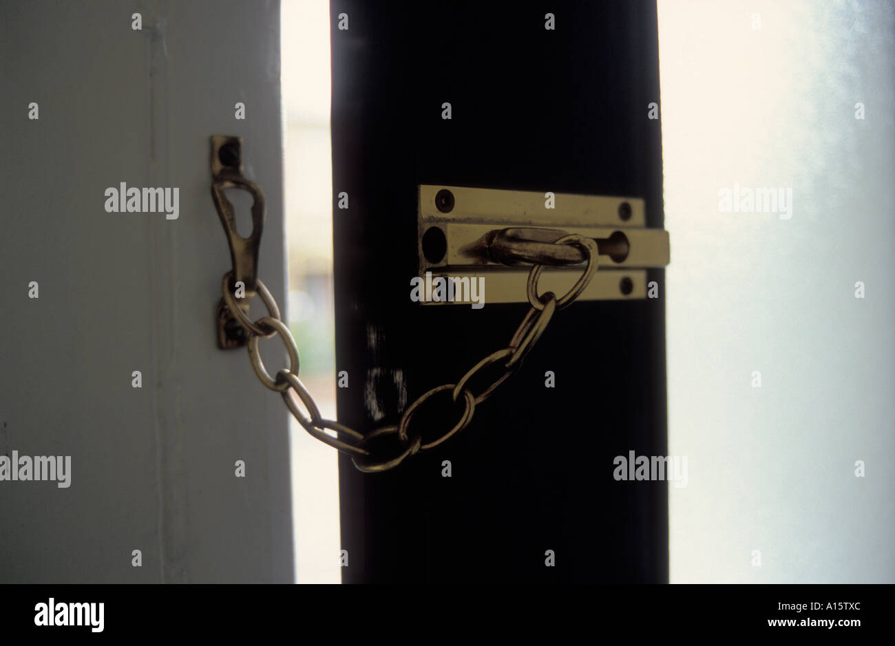 Chain on a slightly opened door Stock Photo - Alamy
