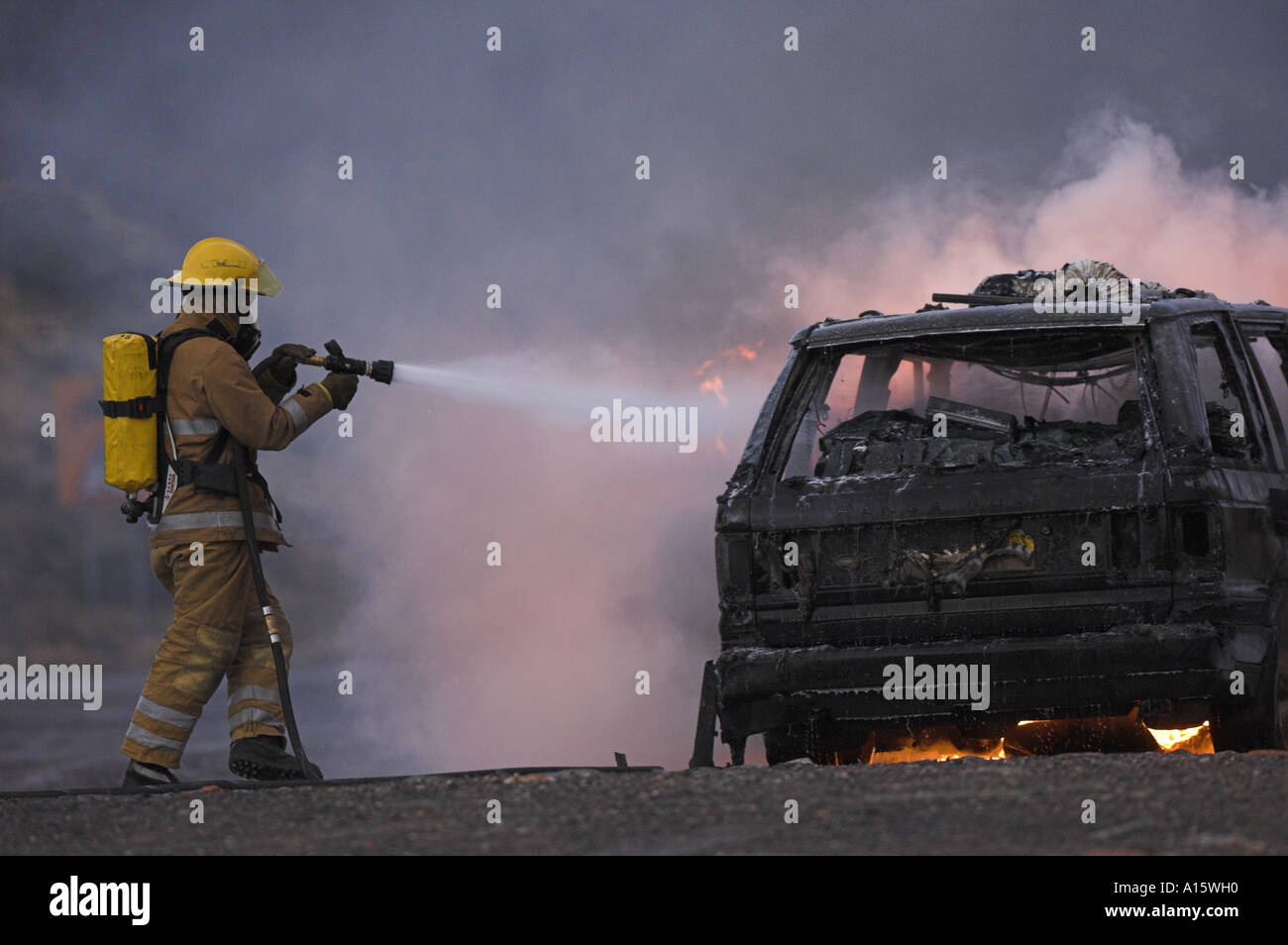 Firefighter at the scene of a burning car Stock Photo - Alamy