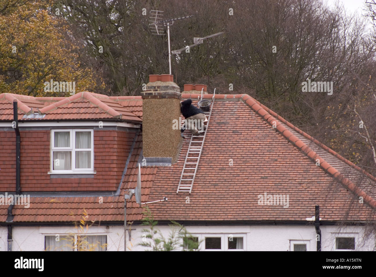 Builder construction Roofer working on roof of residential house with ...