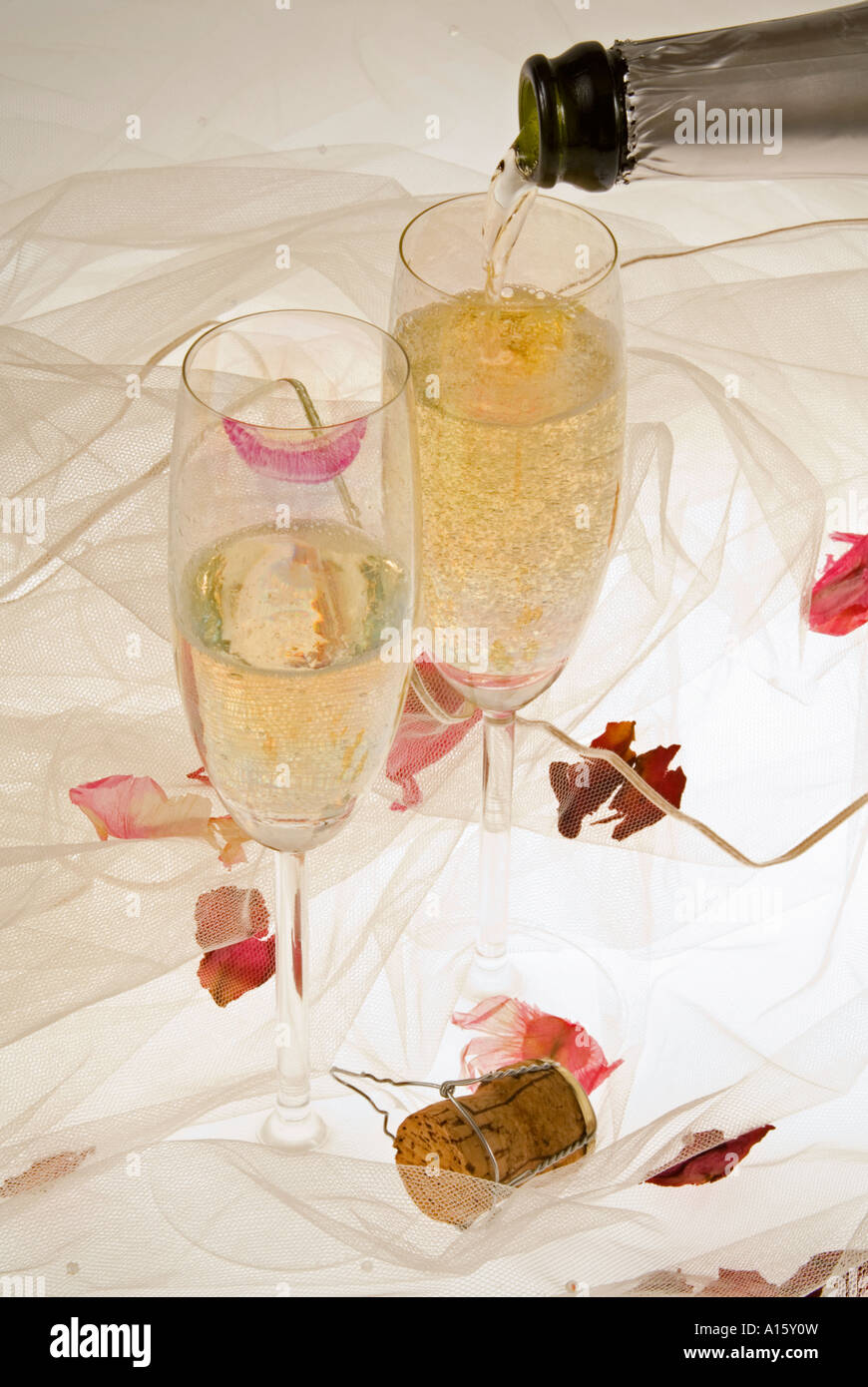 Vertical aerial view of two half empty champagne flutes being refilled ...