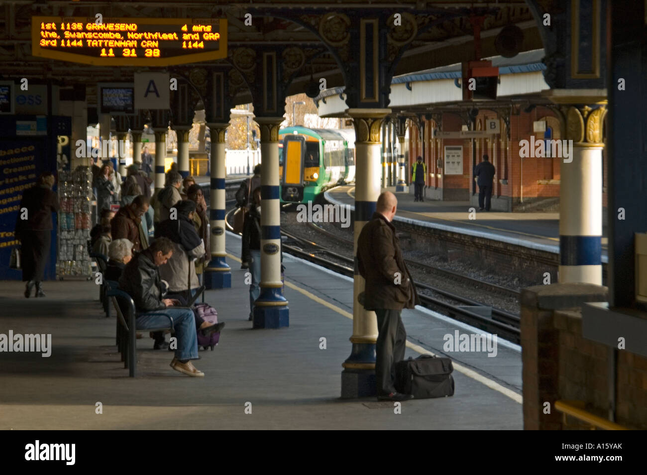Horizontal wide angle of passengers waiting for trains on the platform ...