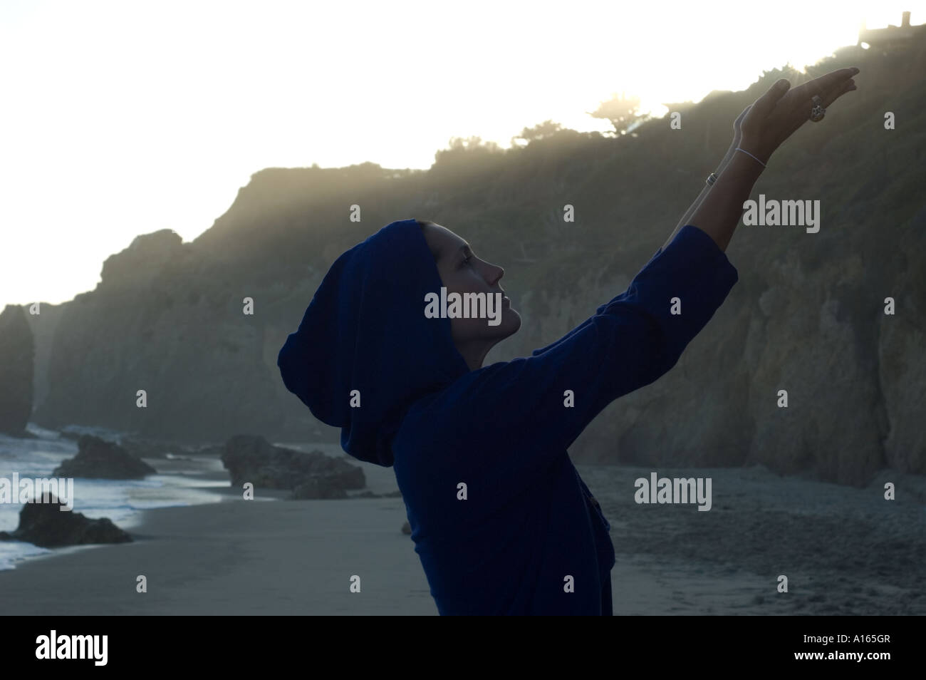 One woman on an empty beach receives last rays of light in a ...