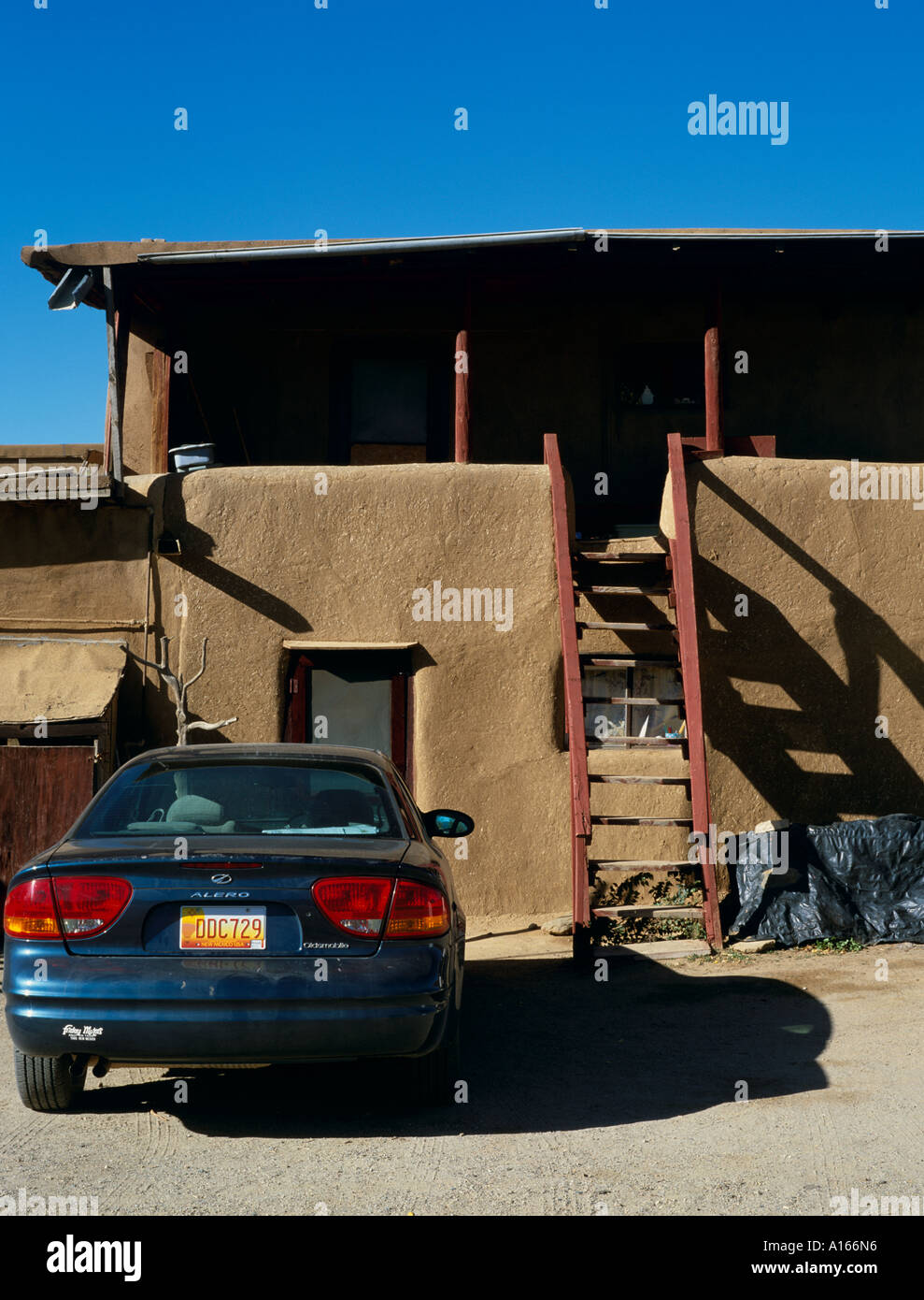Oldsmobile car parked outside mud pueblo famous native American town ...
