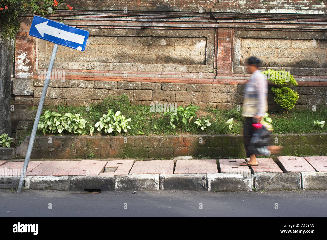 Woman Walking Along Street With One Way Sign Stock Photo - Alamy