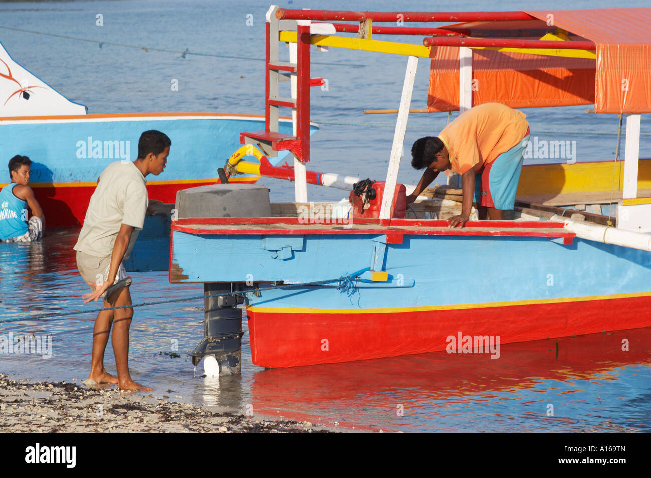 Men Fixing Colourful Boats Stock Photo - Alamy