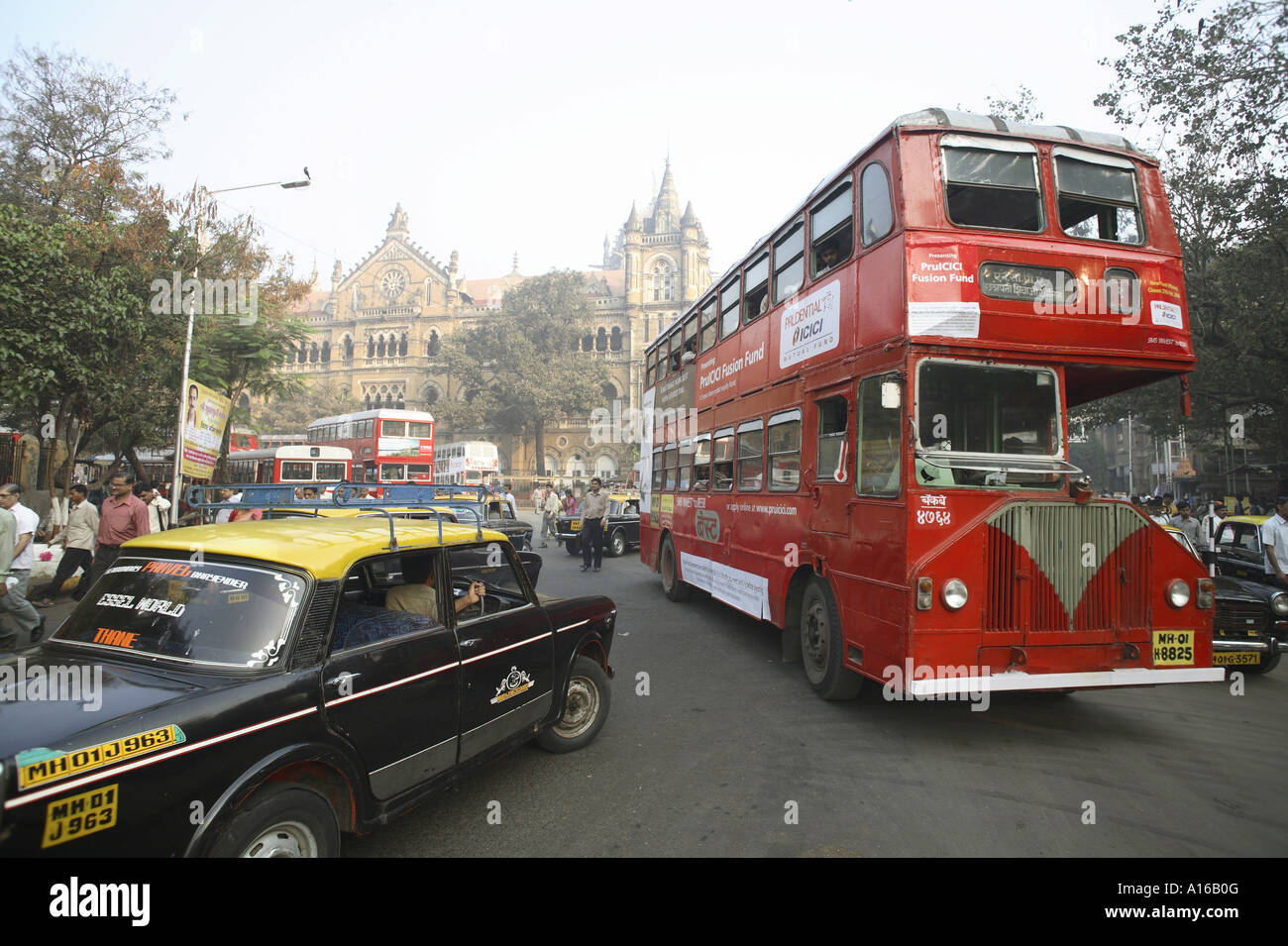 Indian street scene local public transport red bus and black yellow ...