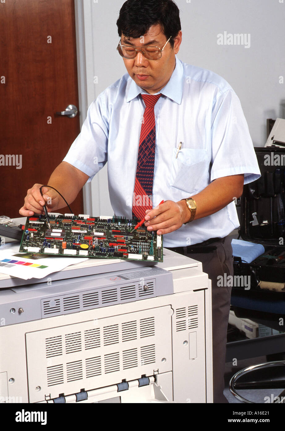 Asian Korean technician repairing copy machine Stock Photo - Alamy