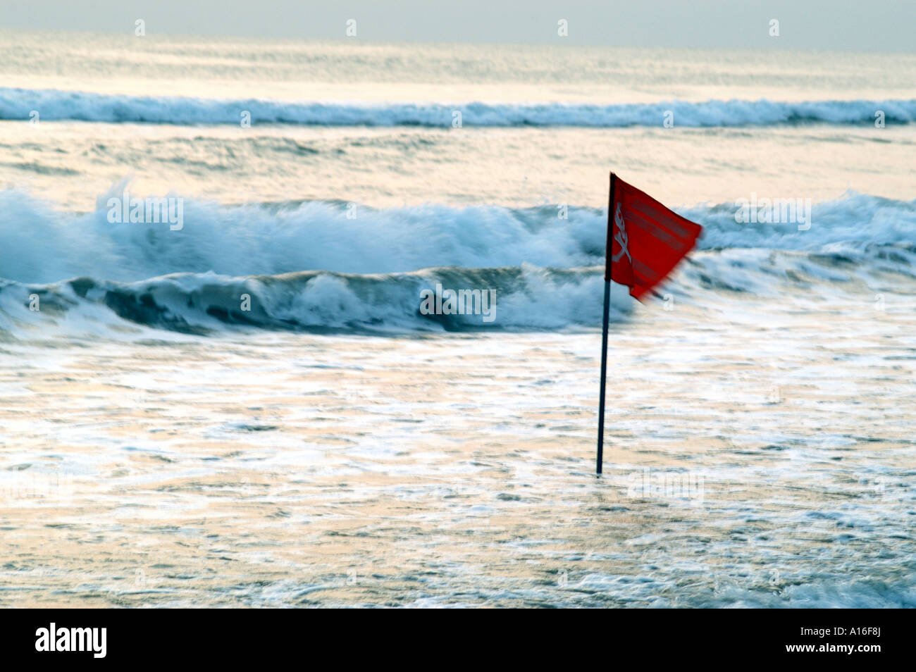 A solitary flag blows in the wind on the sea shore, Bali, Indonesia ...