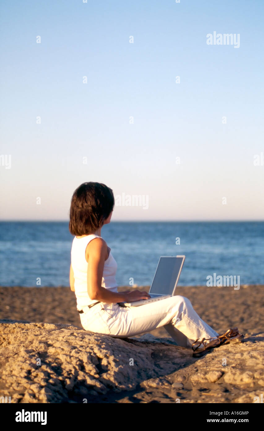 woman with laptop computer on beach Stock Photo - Alamy