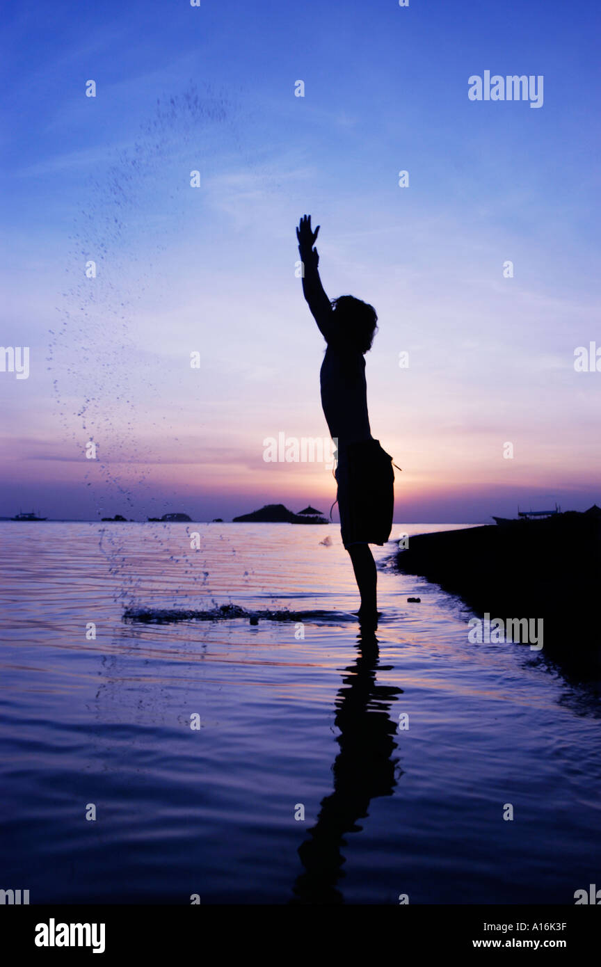 silhouette person in tranquil sea at dusk Stock Photo - Alamy