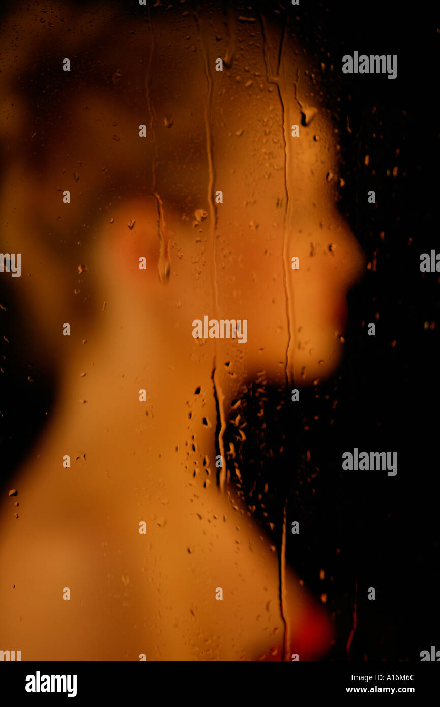 Young woman viewed through rain-covered window Stock Photo - Alamy