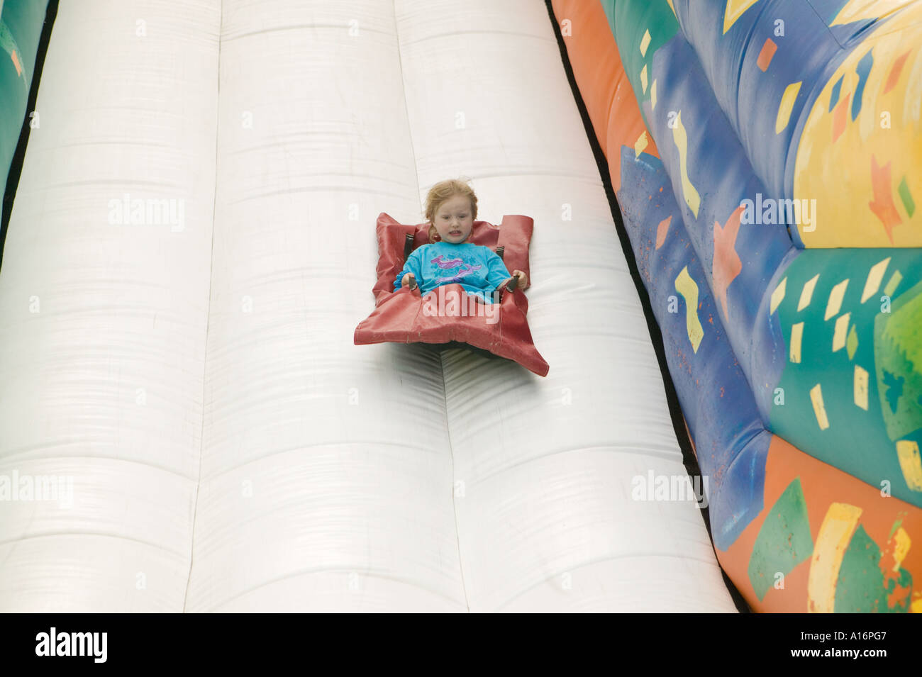 Young girl 3 yrs on inflatable slide Stock Photo - Alamy