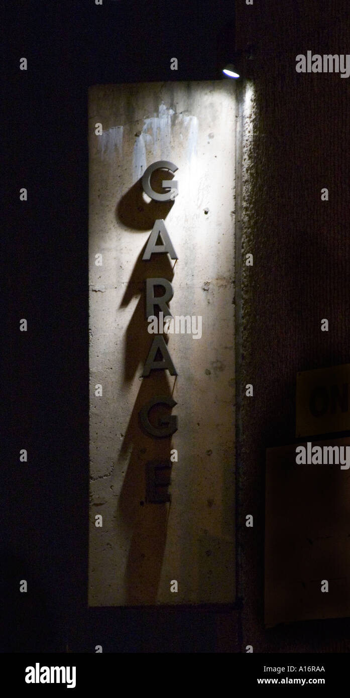 garage parking sign lit up by a spotlight at night in an urban city in ...