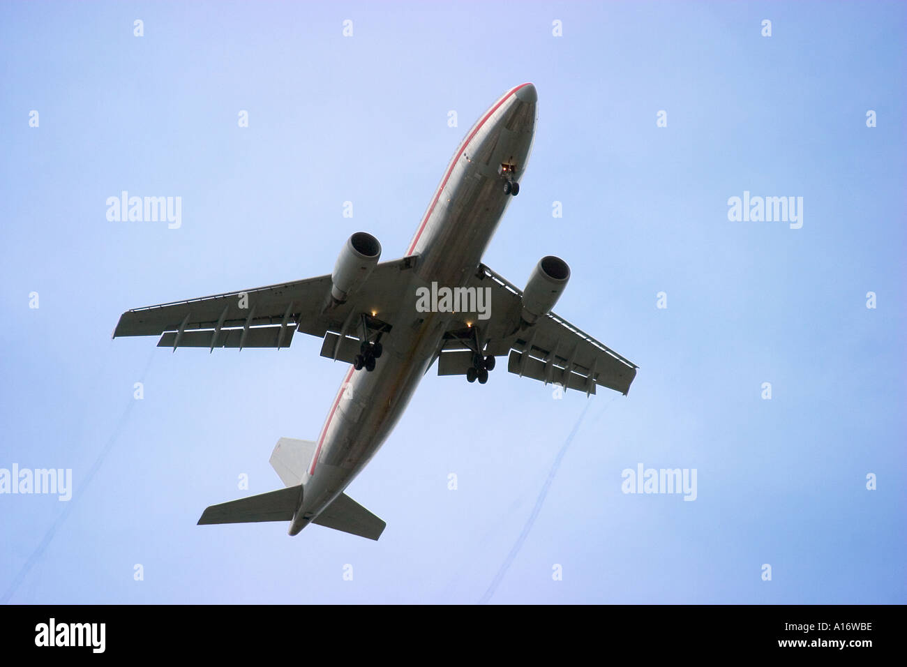 commercial jet airliner airplane taking off angled against a clear blue ...
