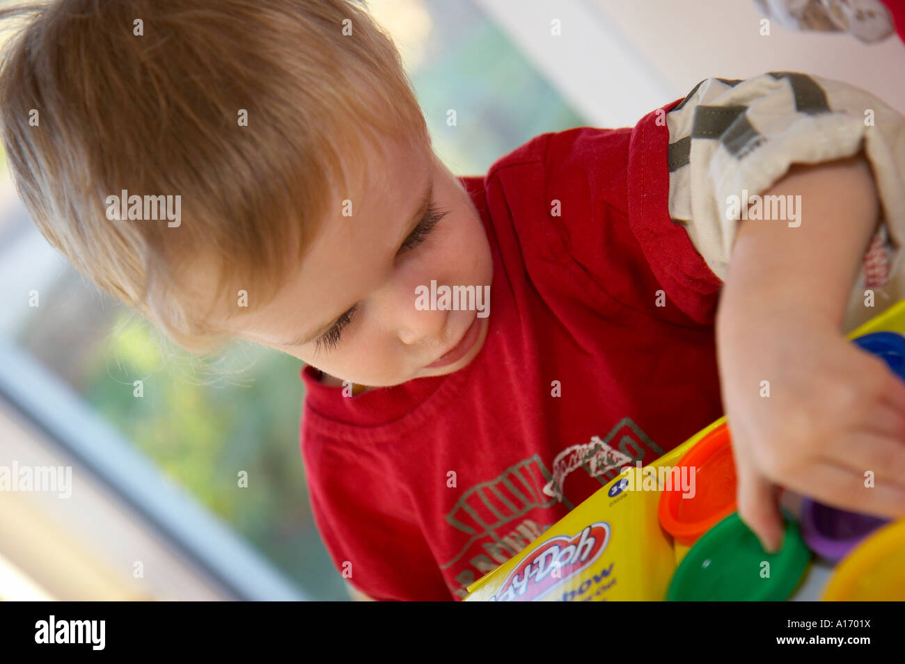 little boy playing with colorful modelling clay Stock Photo - Alamy