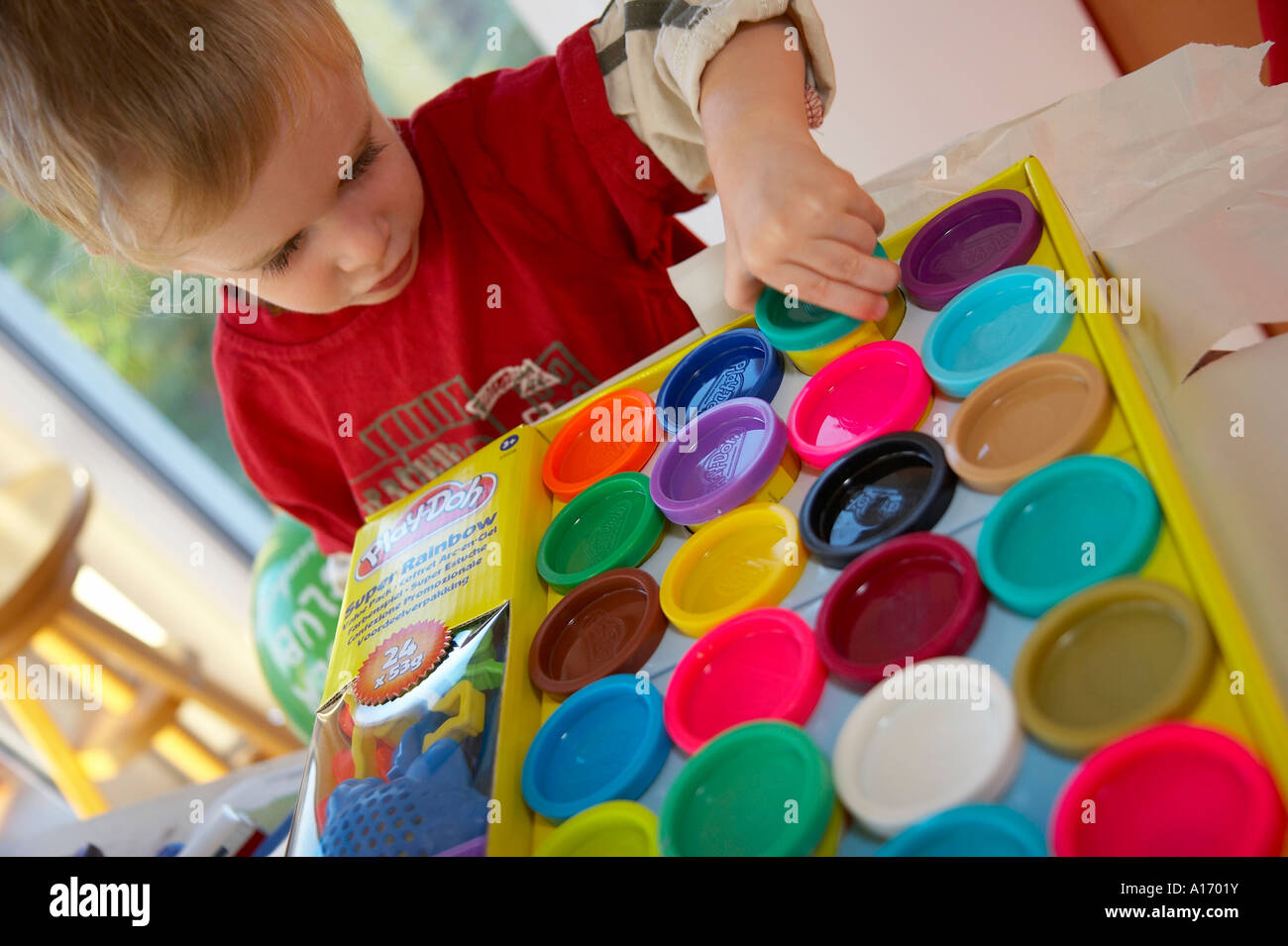 little boy playing with colorful modelling clay Stock Photo - Alamy