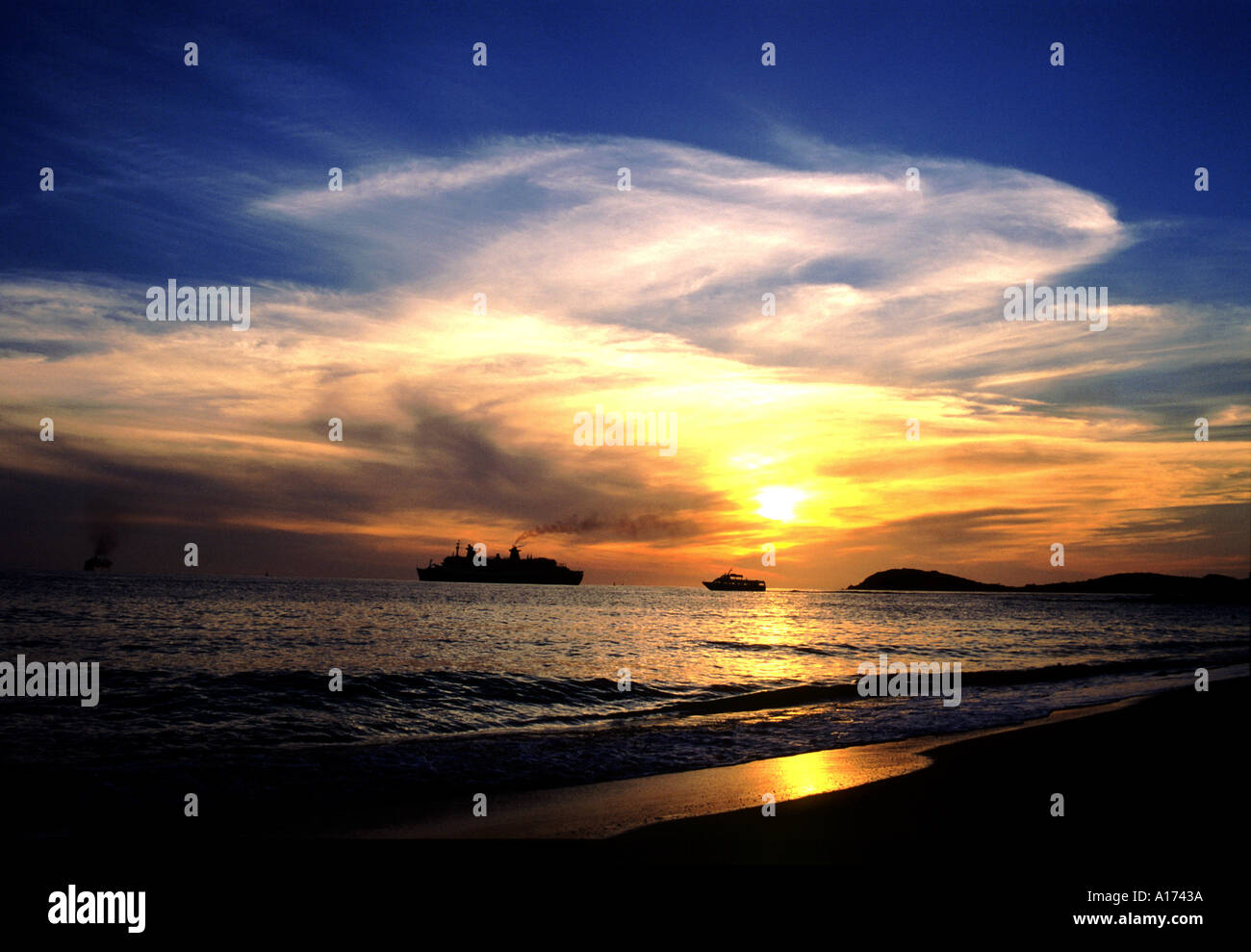 Sunset over tropical beach Stock Photo - Alamy