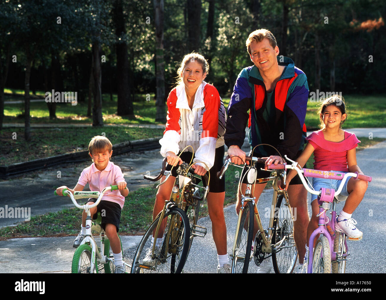 Attractive family riding bicycles together Stock Photo - Alamy