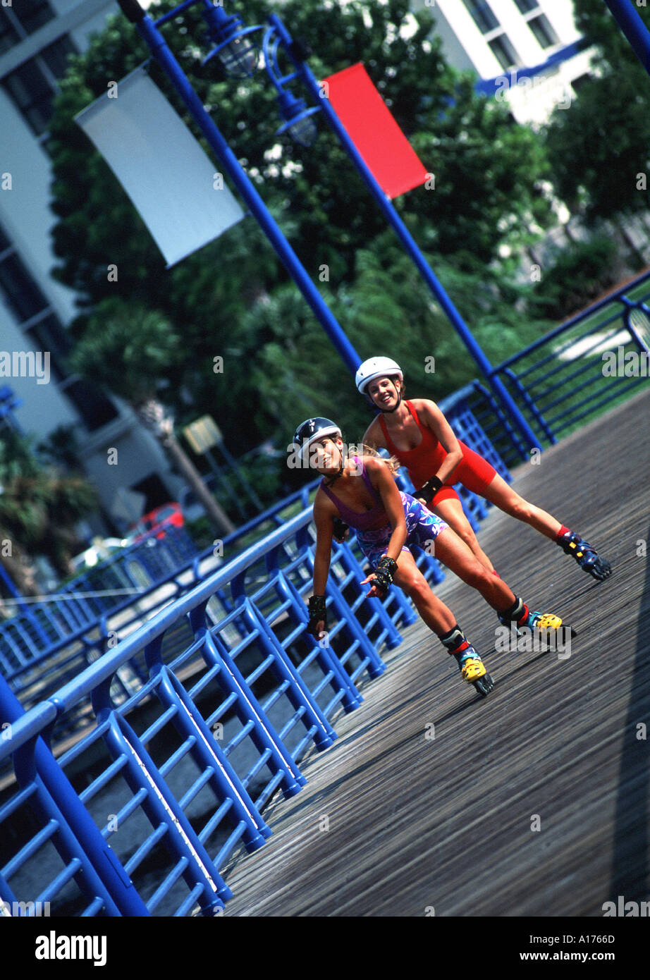 Attractive young women rollerblading outdoors Stock Photo - Alamy