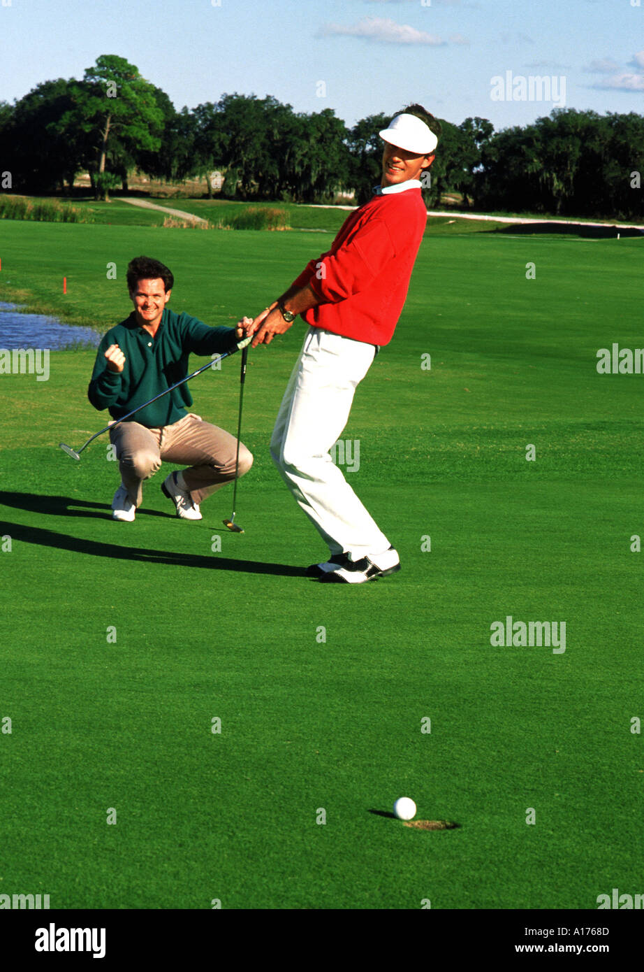 Two men lining up putt on well kept golf course Stock Photo - Alamy