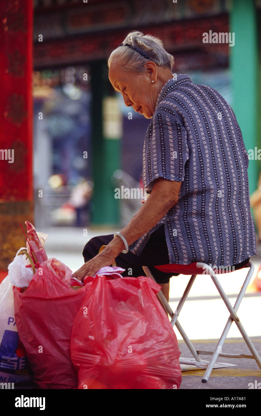 Old lady with bags of offerings in Wong Tai Sin Temple in Hong Kong ...